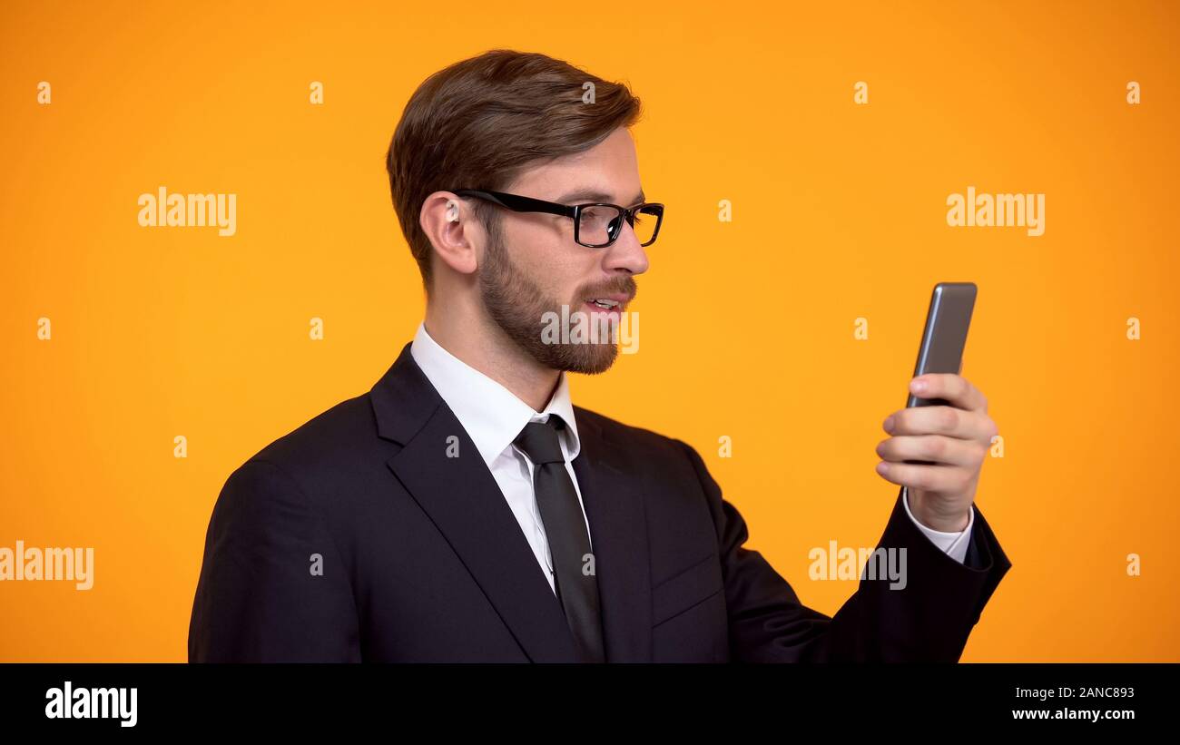 Businessman looking at smartphone screen, reading message or checking ...