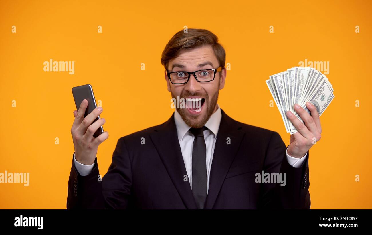 Male looking at smartphone and immediately receiving money cash back ...