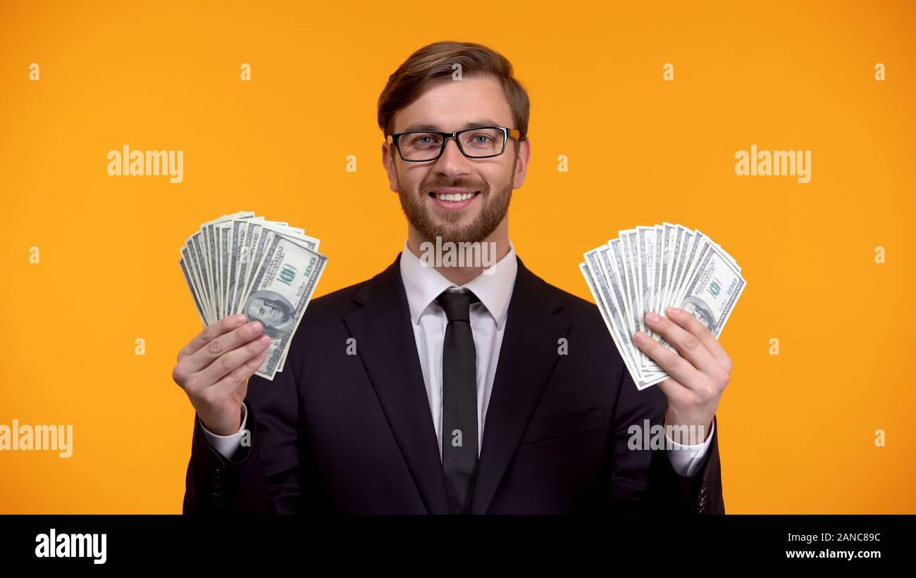 Successful rich man showing bunch of dollars in hands, easy income on ...