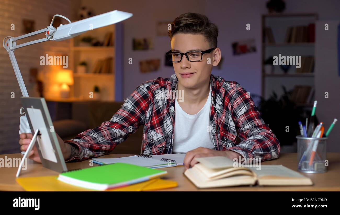 Teenage student missing parents looking at family photo, studying far ...