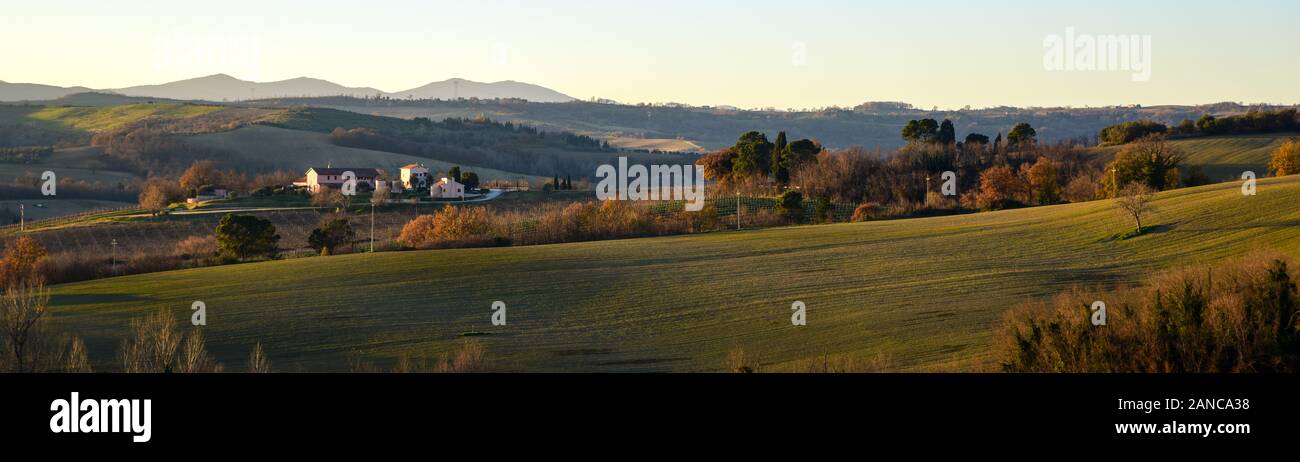 farm in the hills in the warm light of sunset. Countryside and ...