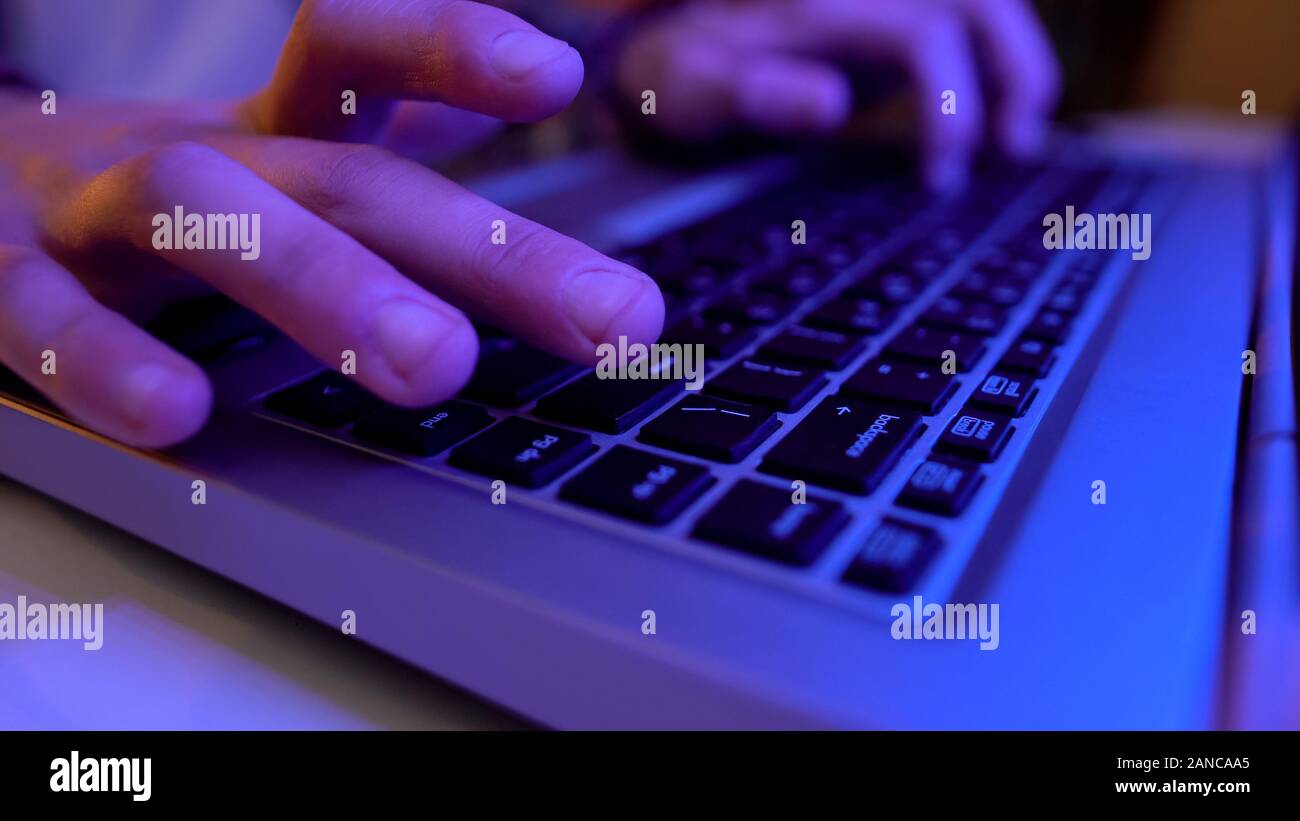 Male hands playing computer game close-up, typing on laptop, leisure ...