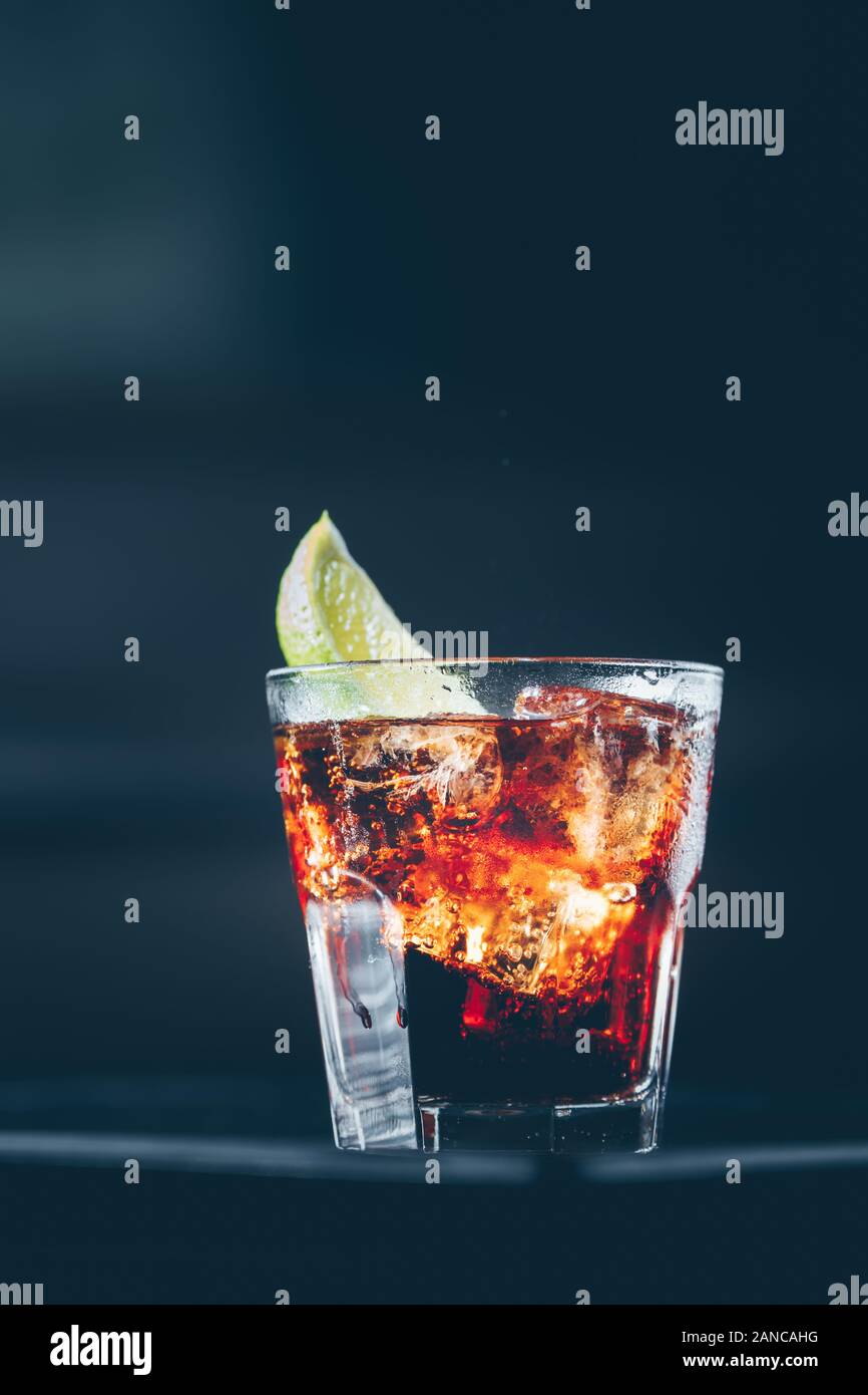 Cuba libre cocktail at the bar stand. Dark background. Vertical Stock ...
