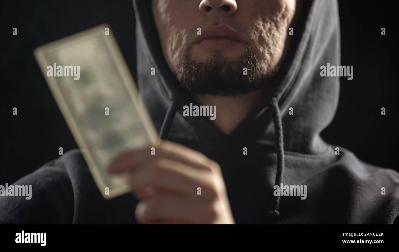 Dangerous gangster holding money in dark room full of smoke, payment ...