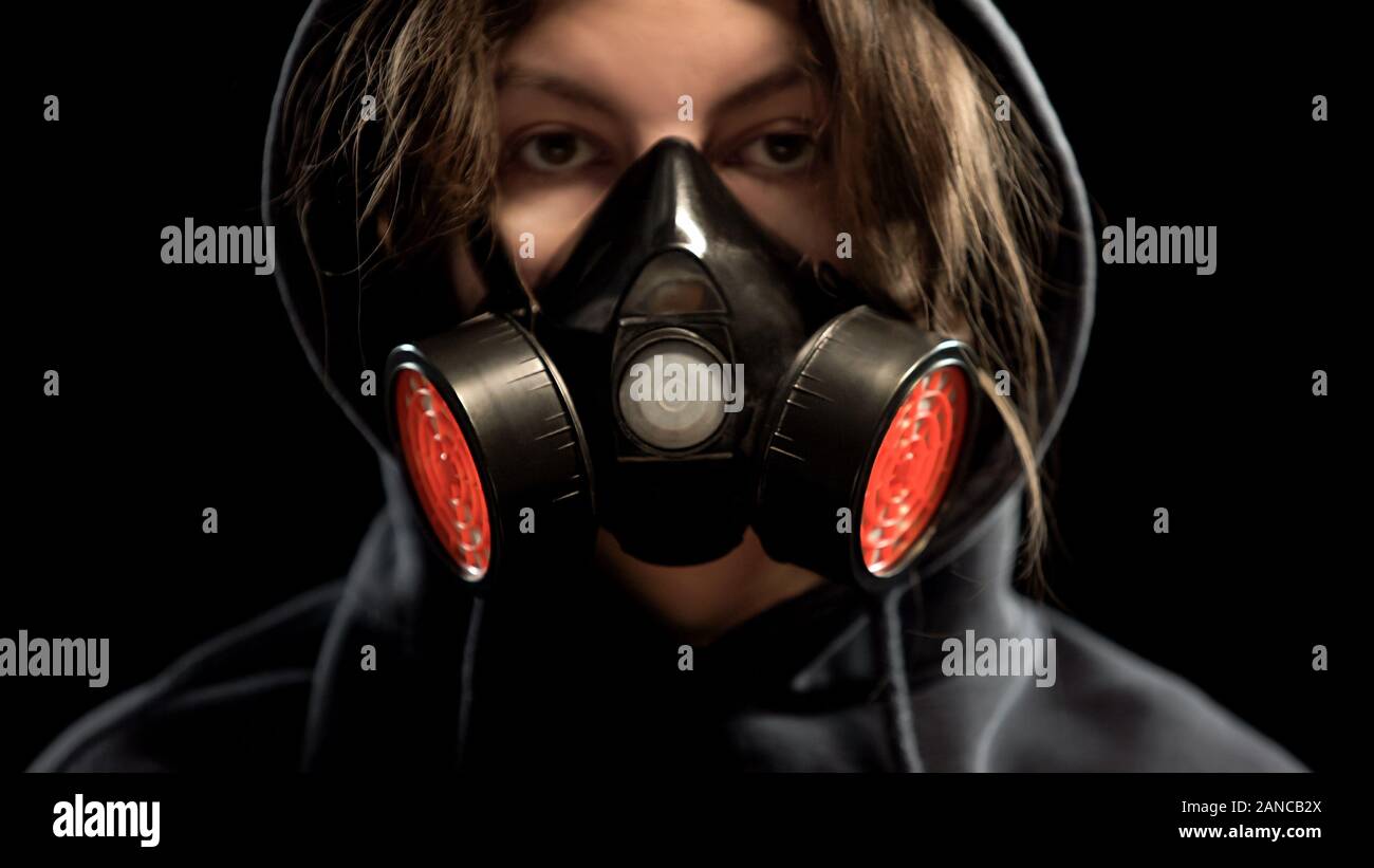 Female in respirator on dark background, protection from gas attack ...