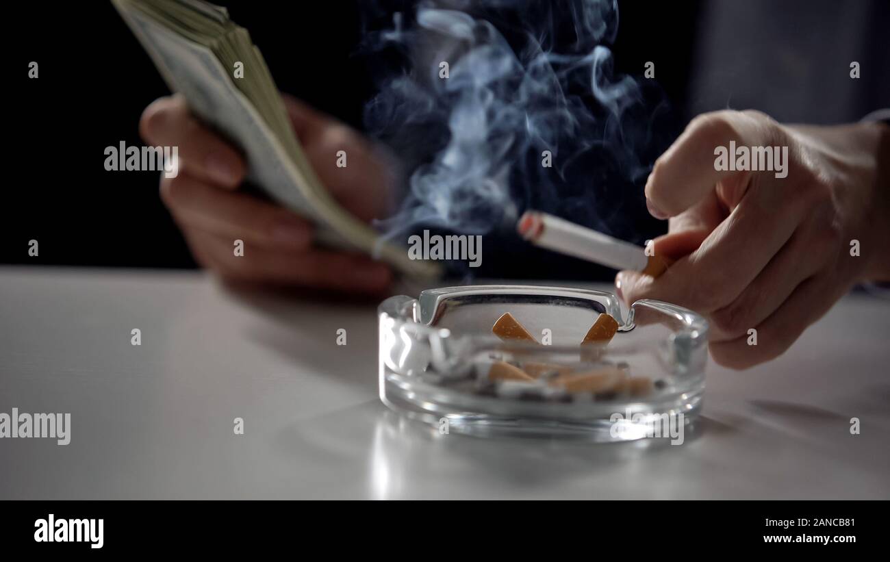Person in suit counting money and smoking cigarette, illegal business ...