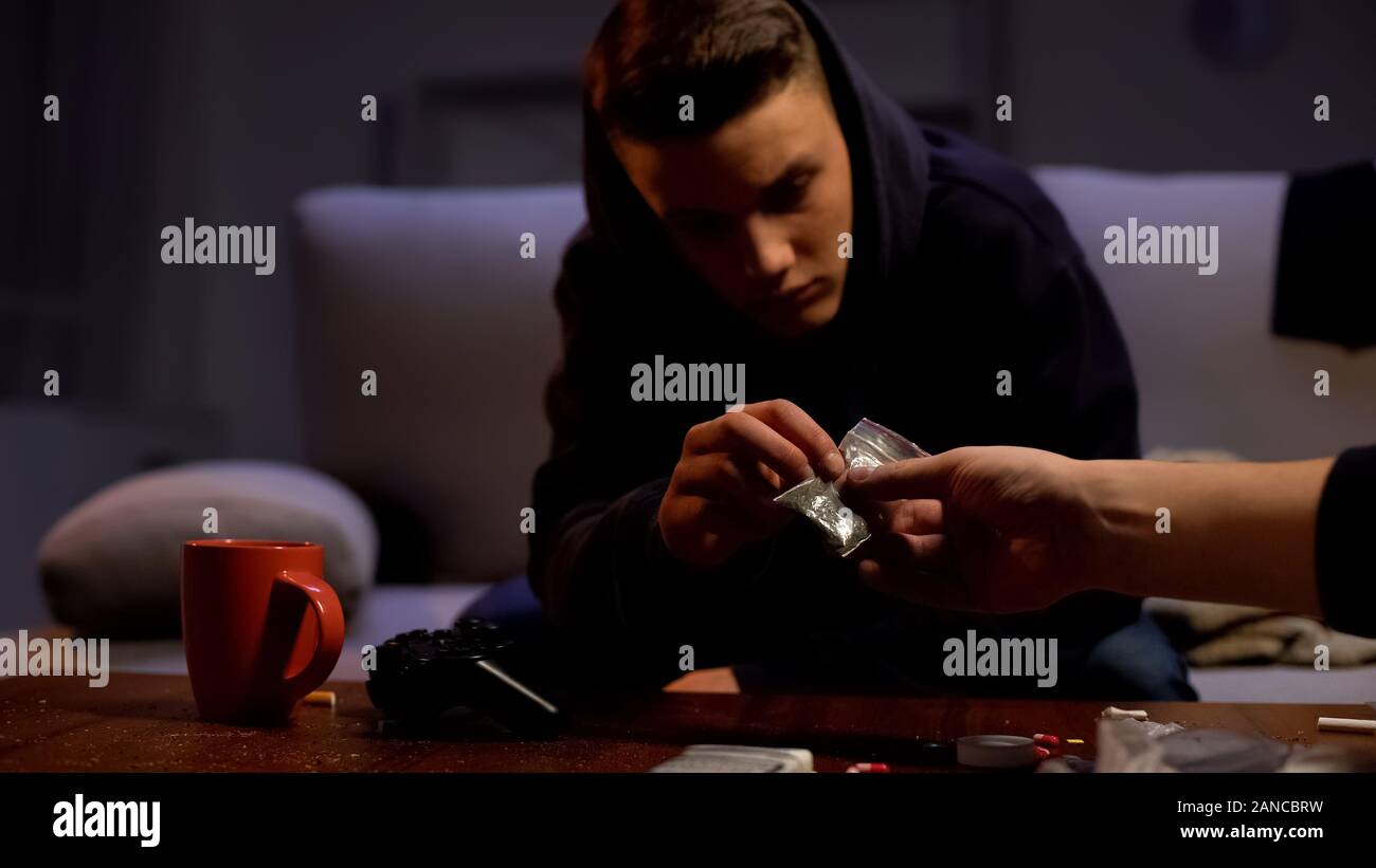 Dealer giving marijuana package to male teenager, drug addiction ...