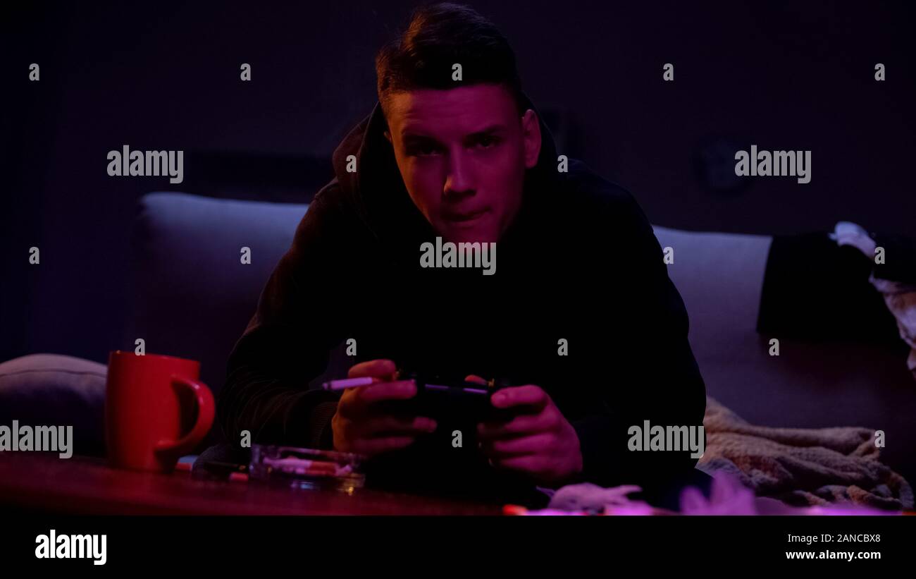 Emotional teenage boy smoking and playing computer game, nicotine ...