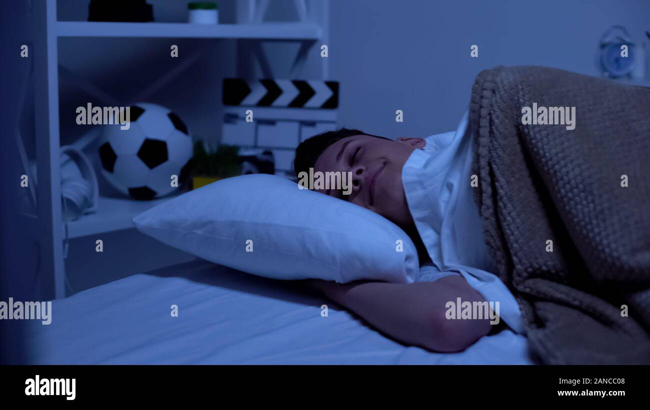 Teen boy sleeping in bed and smiling hi-res stock photography and ...