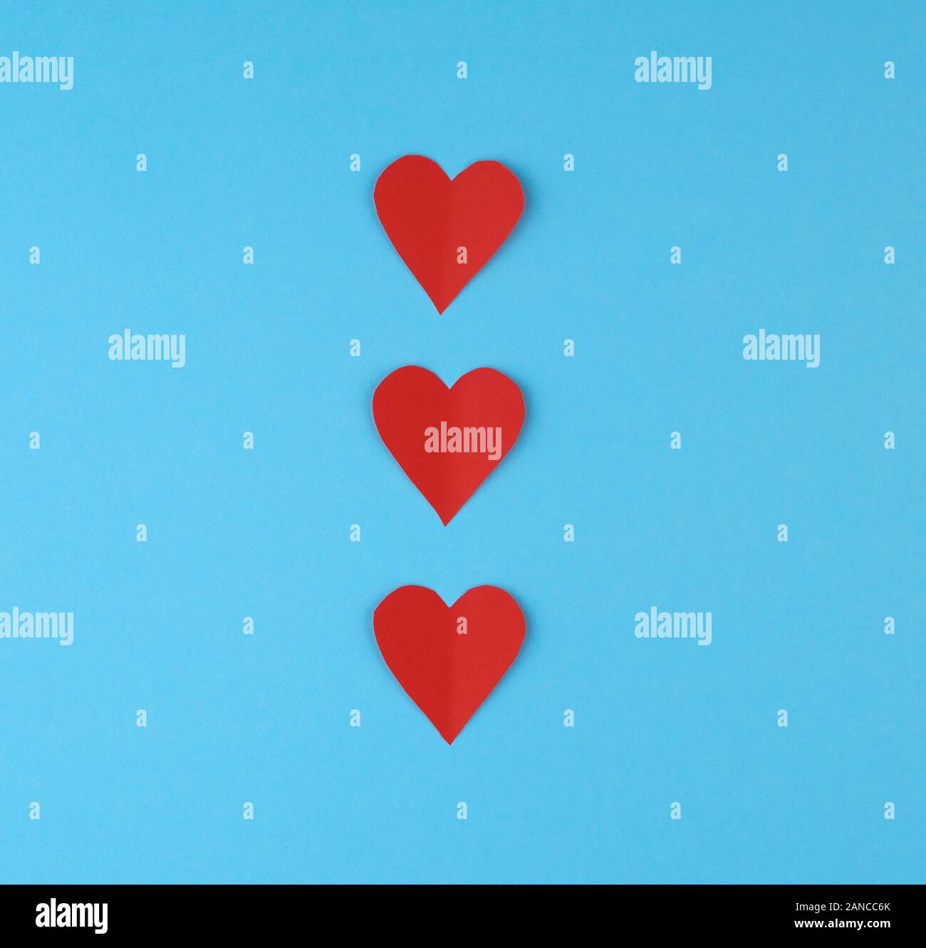 hearts cut out of red paper on a blue background, festive backdrop for ...