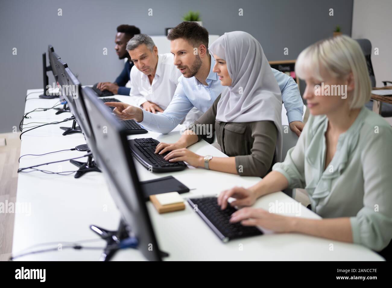 Young Businessman Helping His Colleagues In The Work Of Office Stock ...