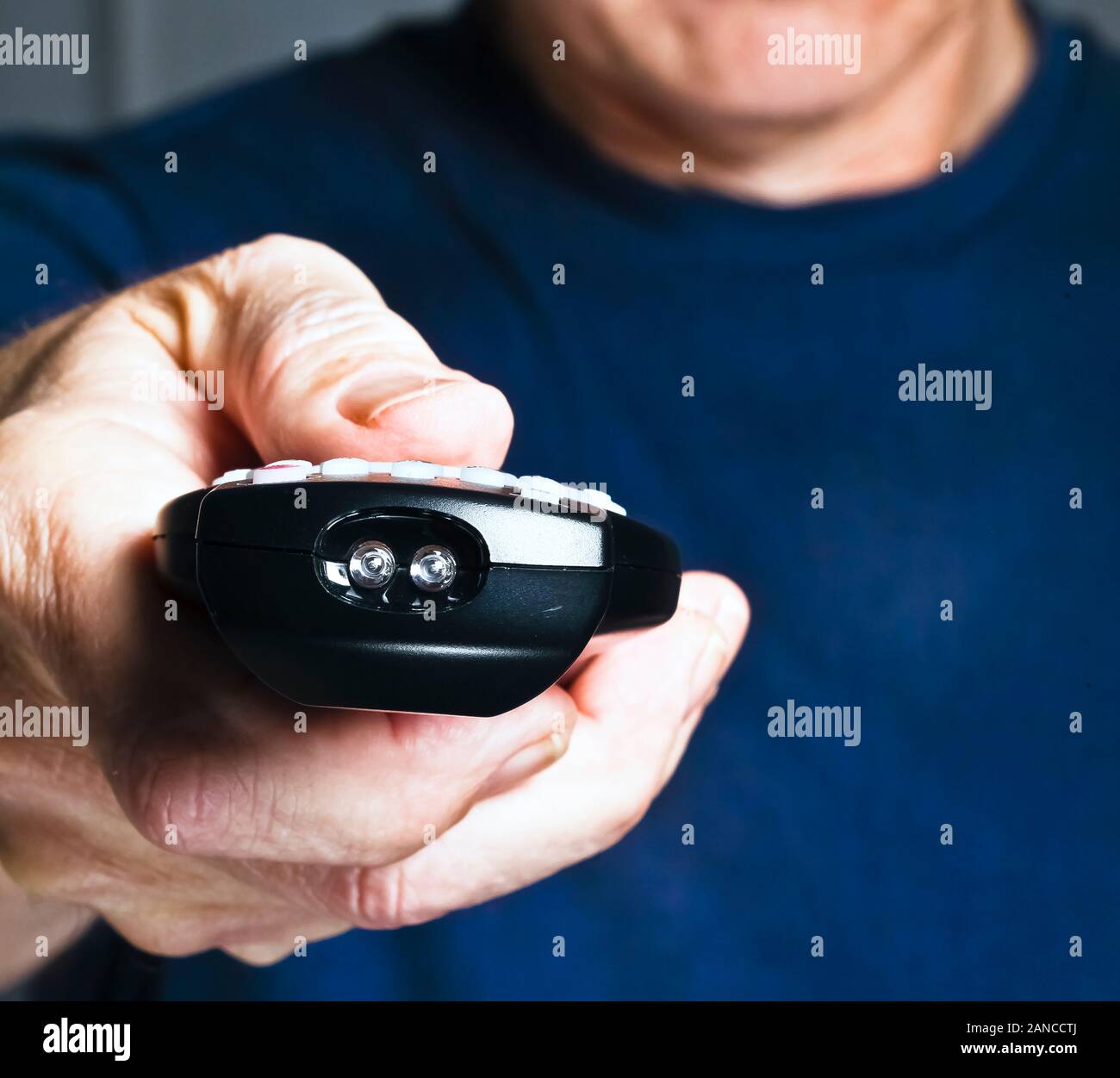 older man's hand holding tv remote control clicker Stock Photo - Alamy
