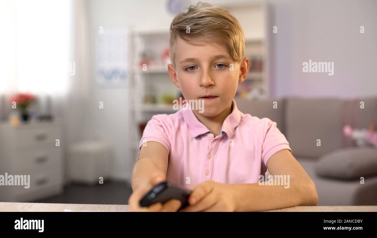 Male kid watching television instead drawing, changing channels remote ...