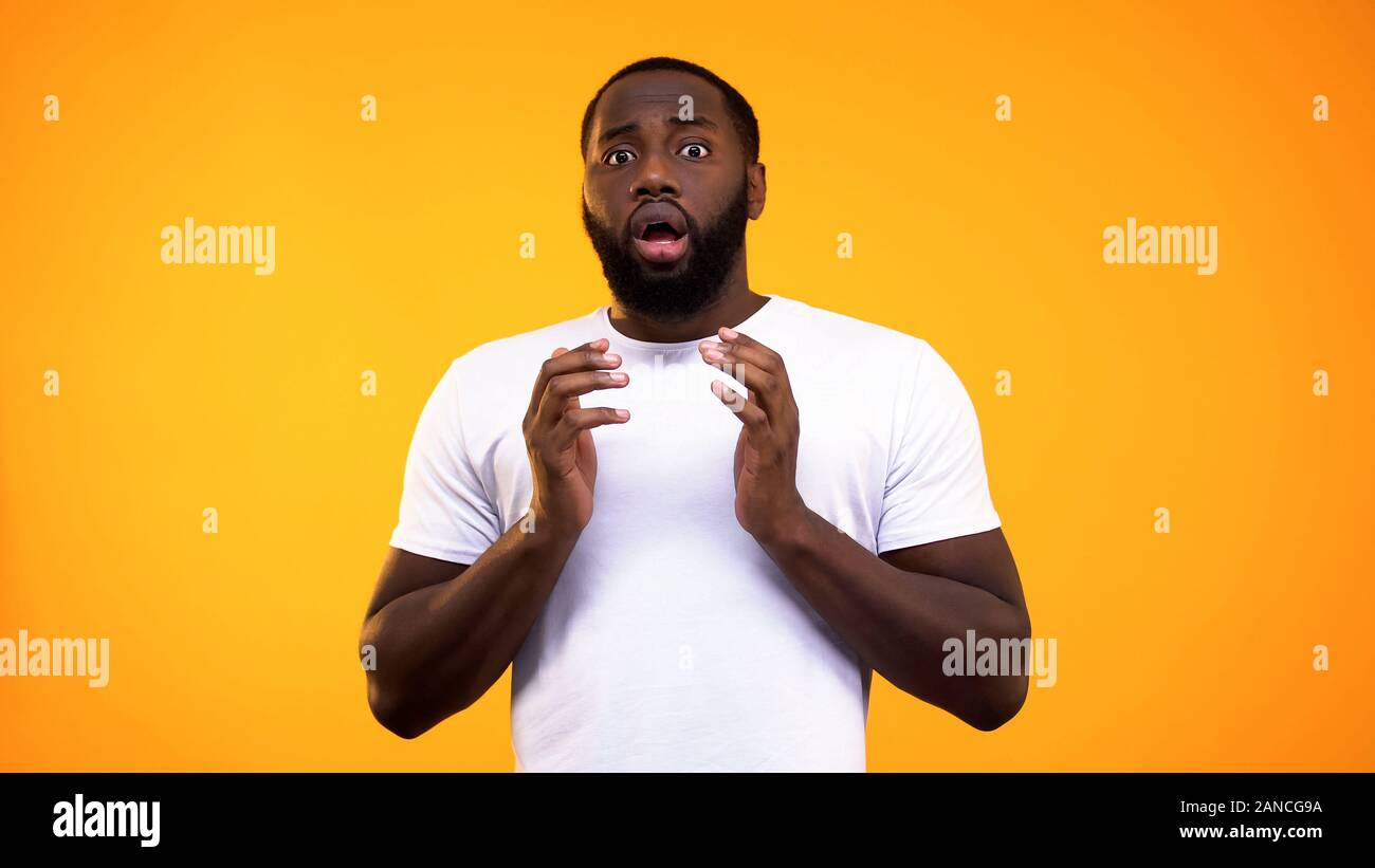 Scared afro-american man on bright background, shocking news, horror ...