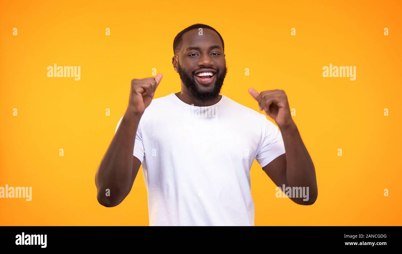 Happy african american man dancing on yellow background, celebrating ...