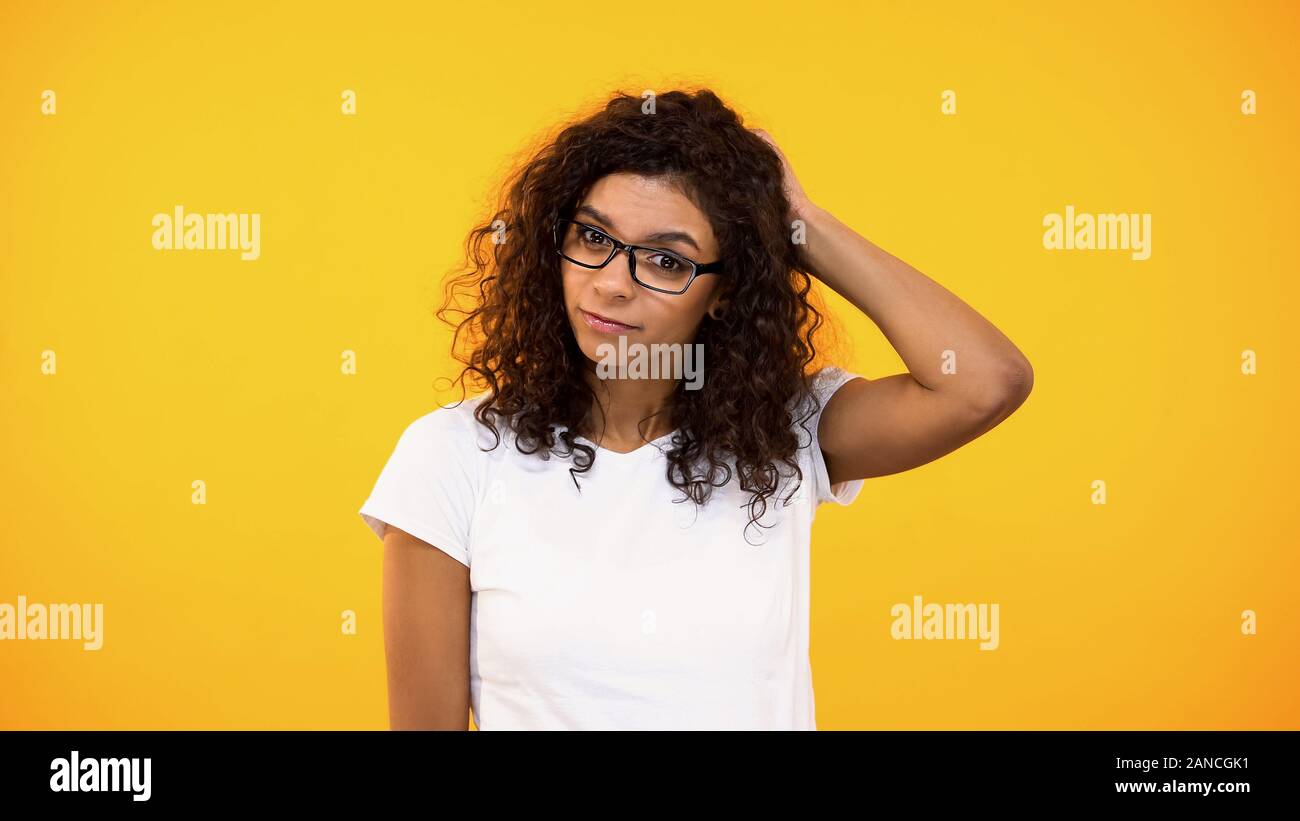 Pensive biracial woman touching back of head, unsure of choice, making ...