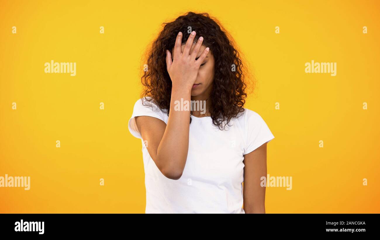 Discontent biracial lady gesturing face palm on camera against yellow ...