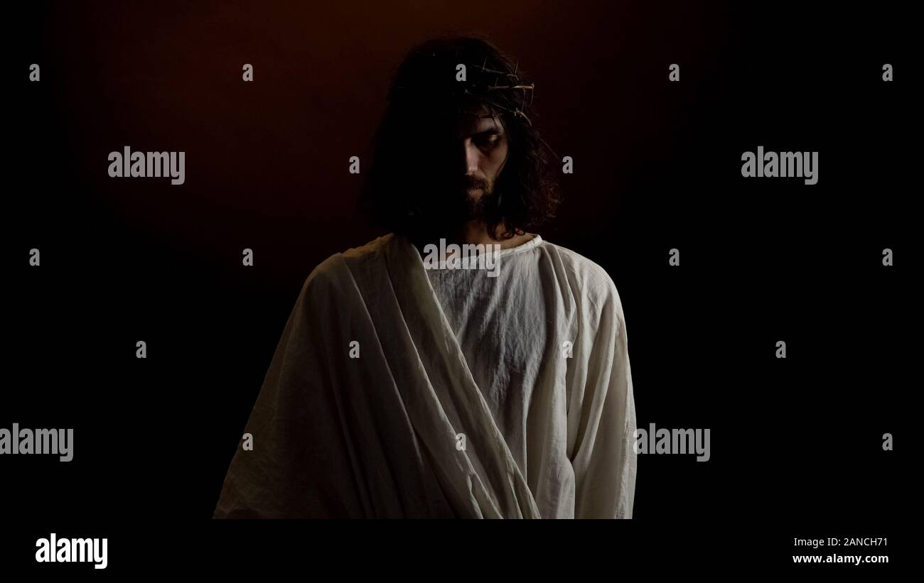 God Jesus in crown of thorns standing in dark, punishment for mortal ...