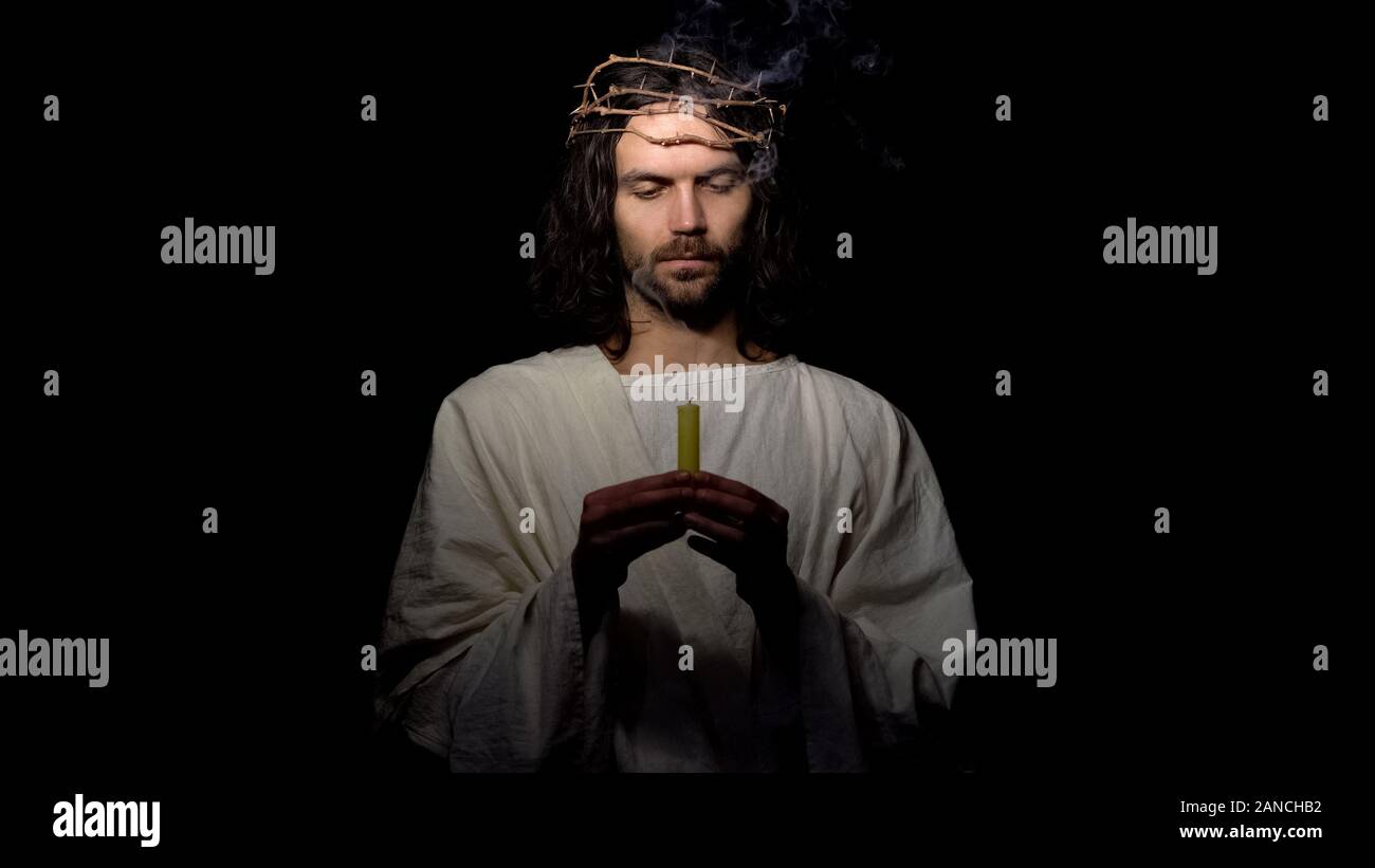 Jesus Christ holding blown candle, praying for people sins expiation ...