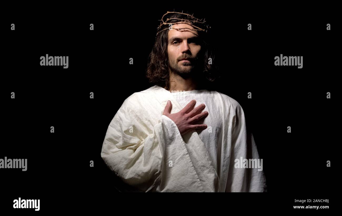 Christian prophet in crown of thorns crying, put hand on chest asking ...