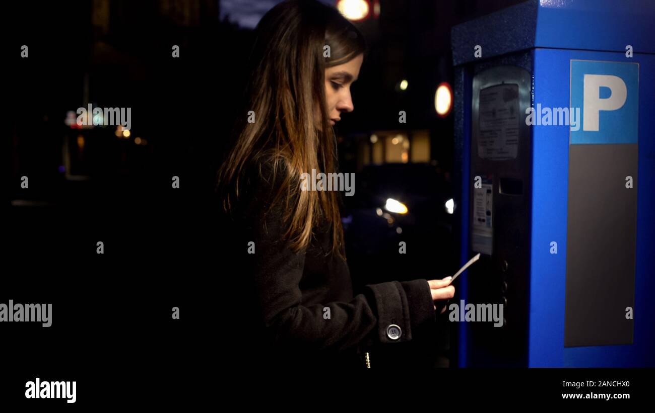Lady buying ticket from parking payment machine at night, crime risk ...