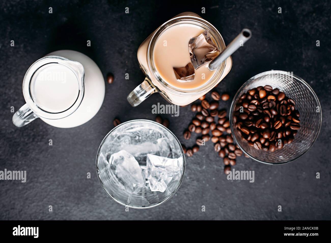 Cold iced coffee with ingredients: ice cubes, milk, coffee beans Stock ...