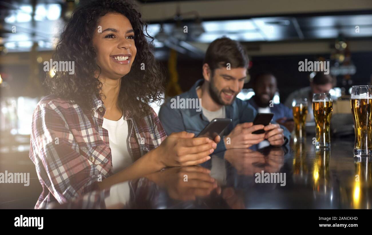 Joyful female happy about winning bet on sports game in pub ...