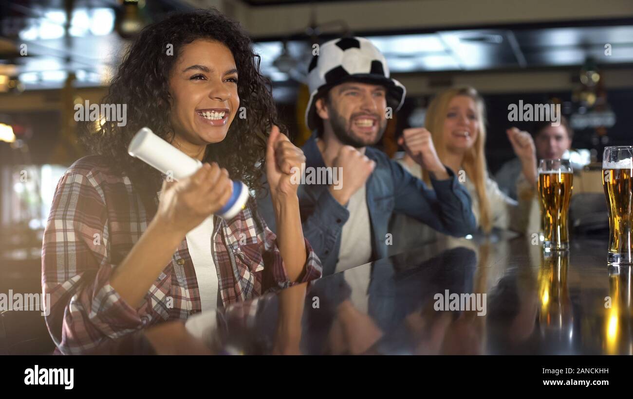 Cheerful soccer fans supporting favorite team in pub, men and women ...