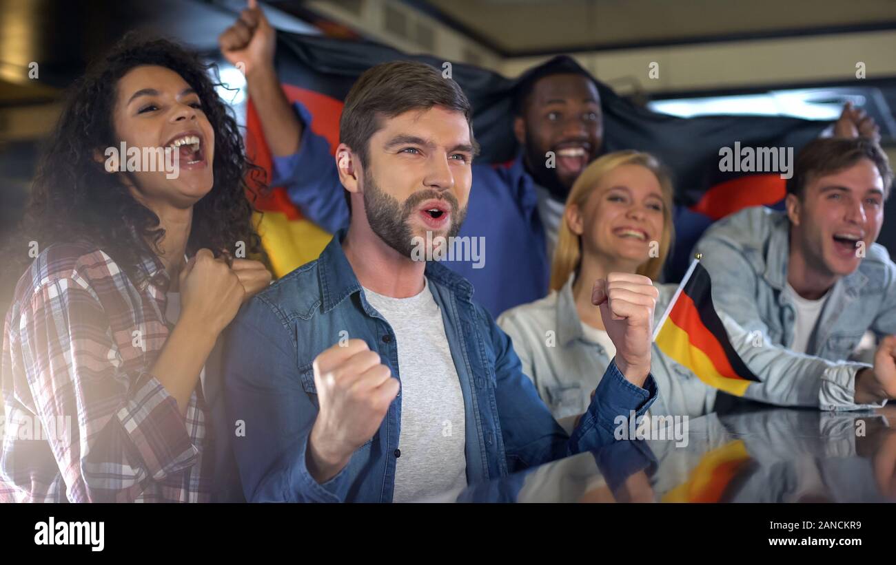 Enthusiastic german sports fans holding flag, happy about national team ...