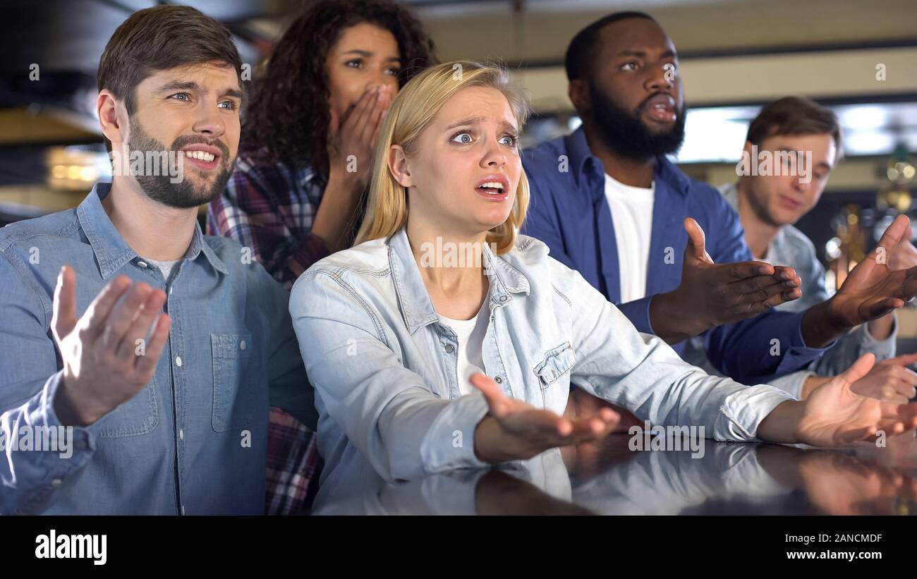 Emotional multi-ethnic friends rising hands, upset with favorite team ...