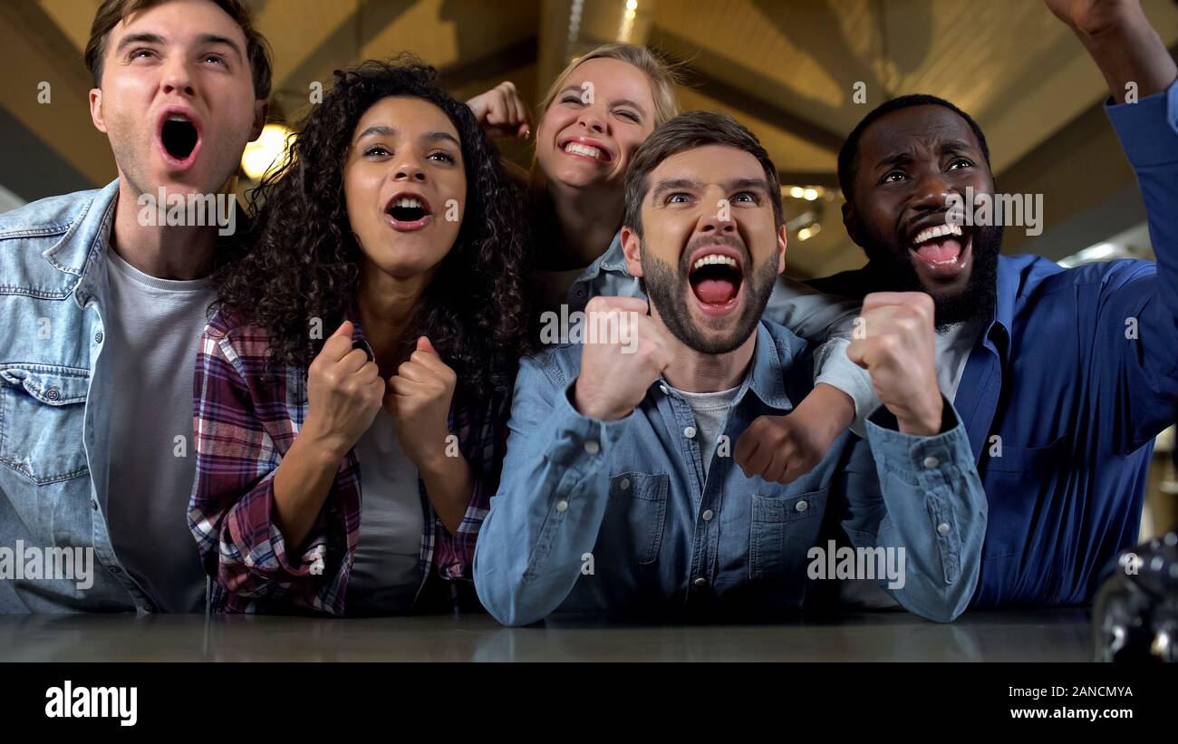 Excited young people supporting team, watching match together ...