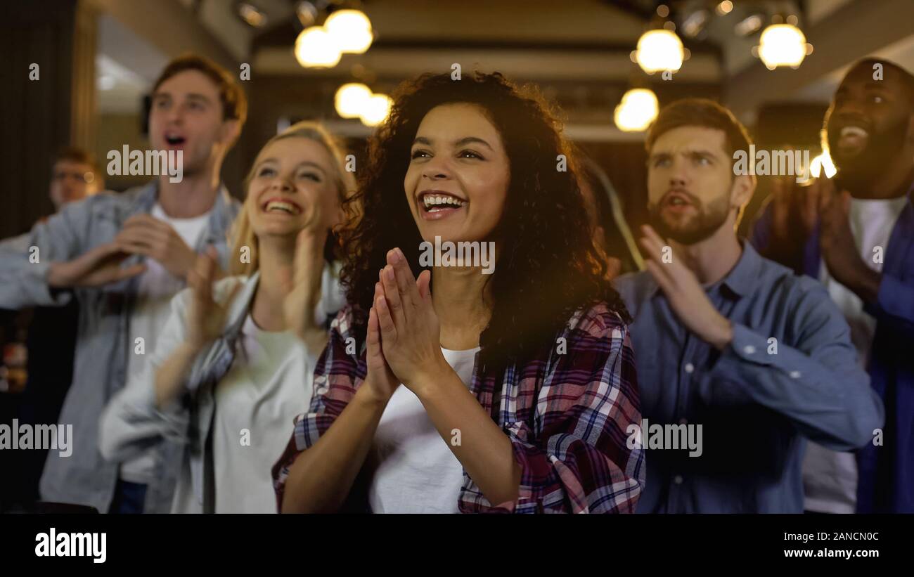 Positive sport fans cheering, clapping hands together and shouting ...