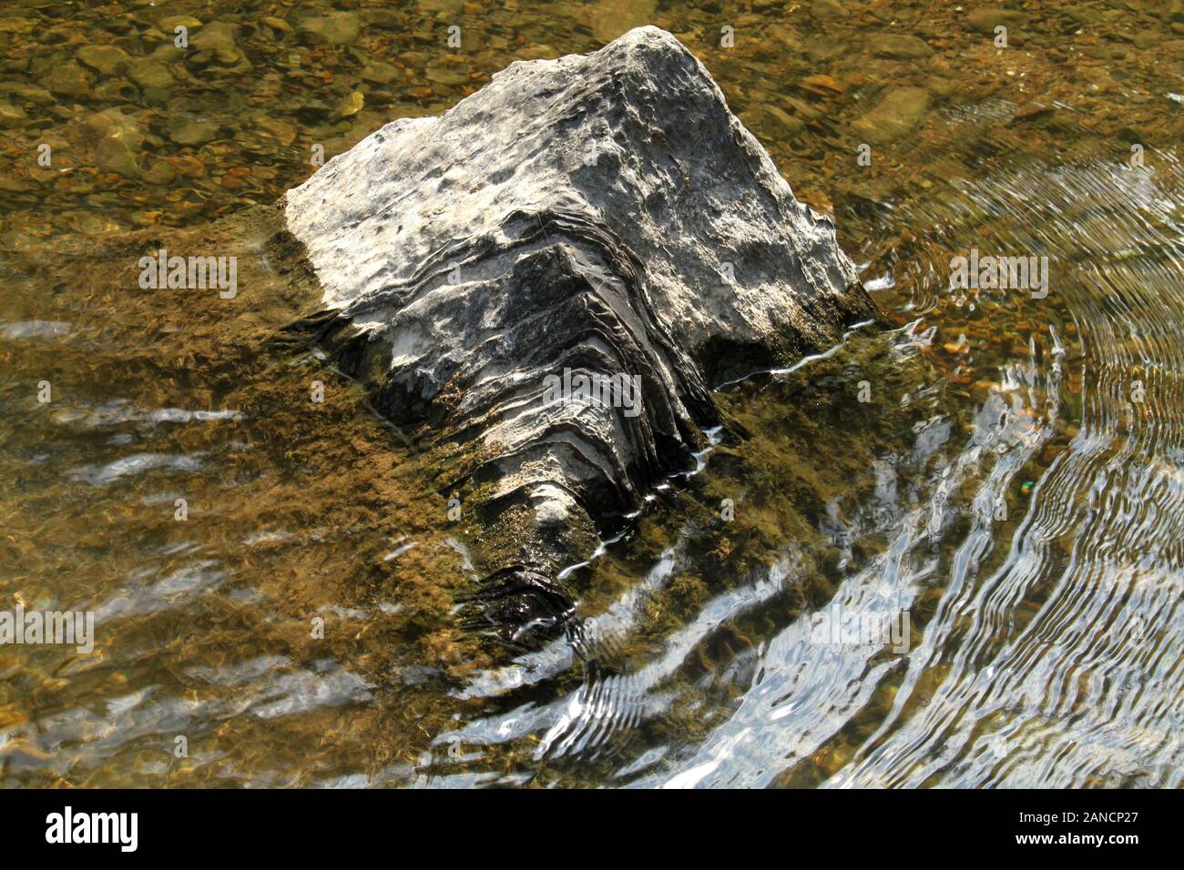 Large rock in a creek, with erosion marks Stock Photo - Alamy