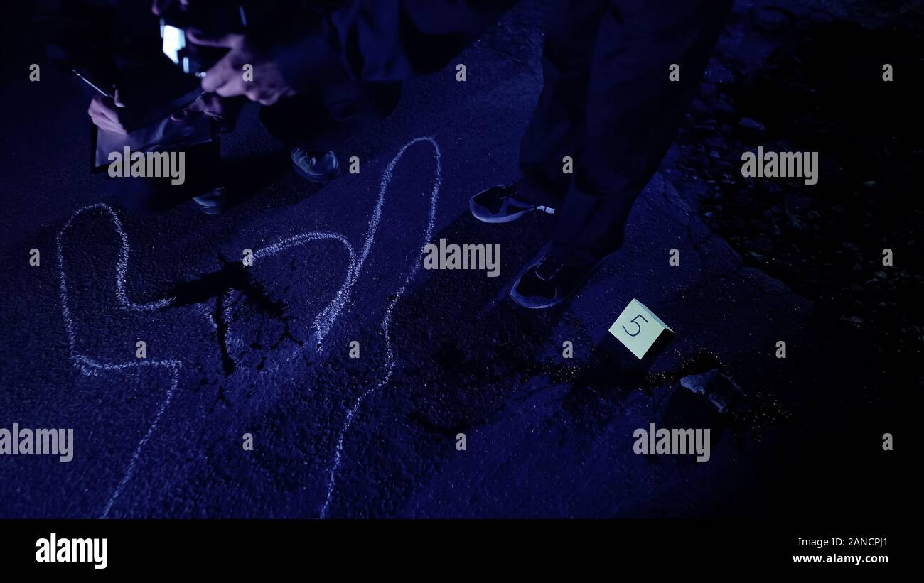 Forensic experts studying evidence on murder scene, taking photos ...