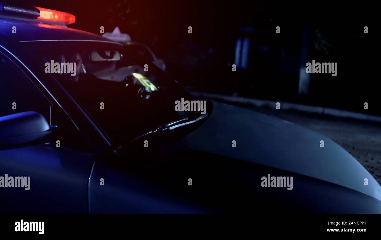 Policemen patrolling city driving in car with flashing light, public ...