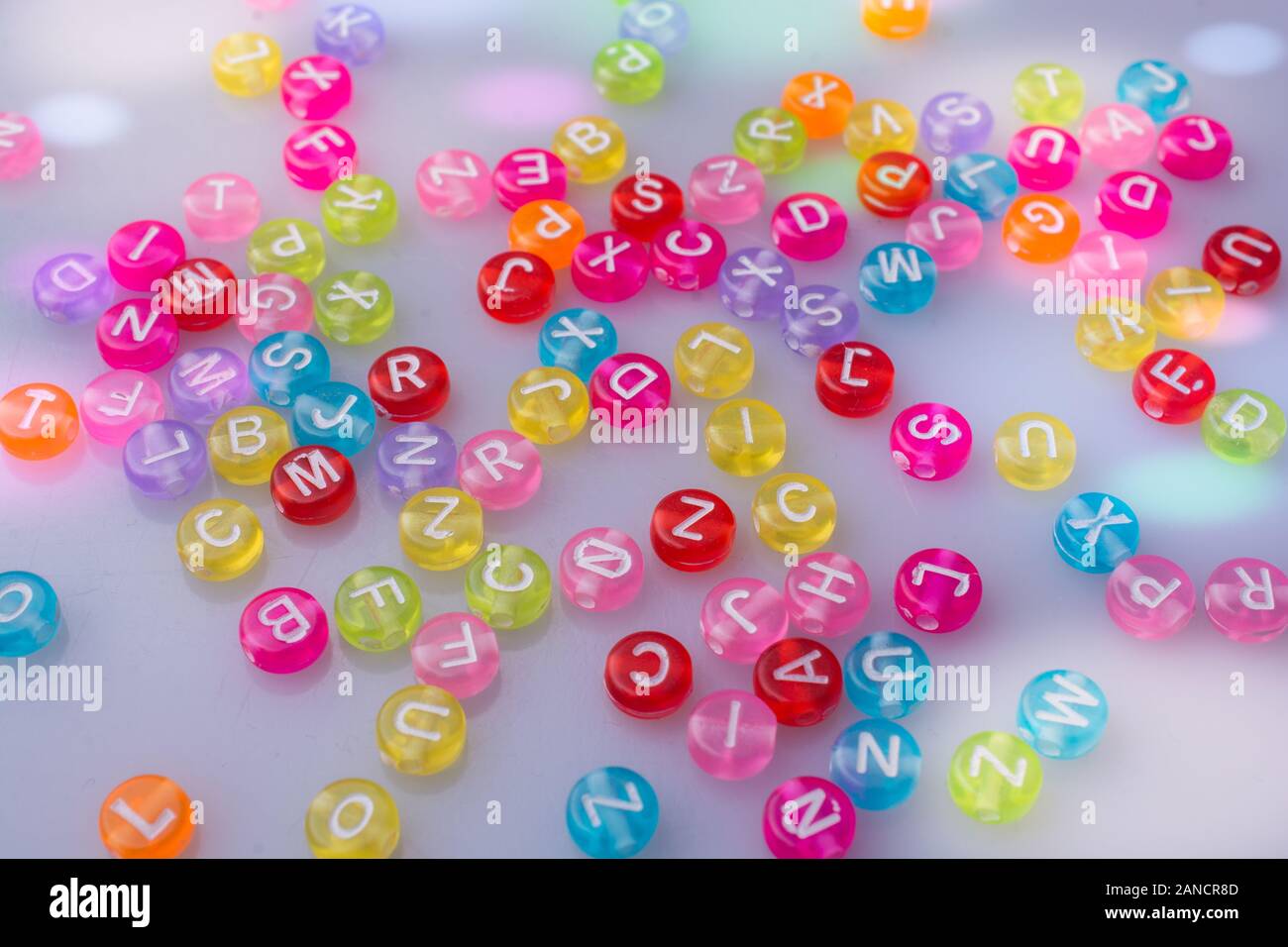 Multi color alphabet letter beads scattered randomly Stock Photo - Alamy