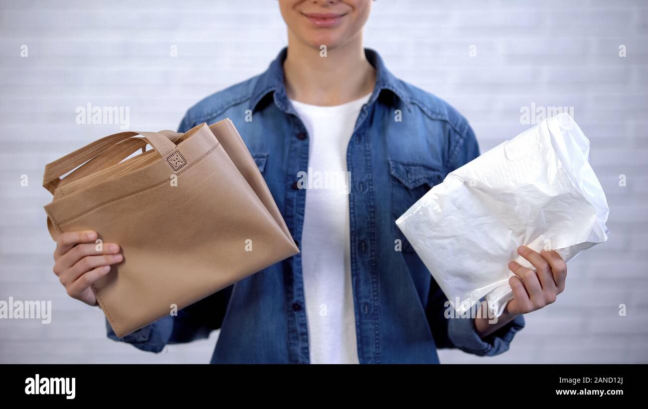 Lady choosing between ecobag and plastic package, pollution with ...