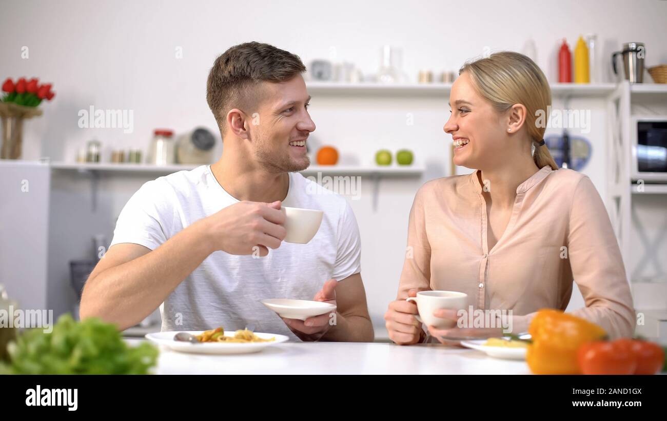 Attractive couple drinking tea after meal for better digestion, water ...