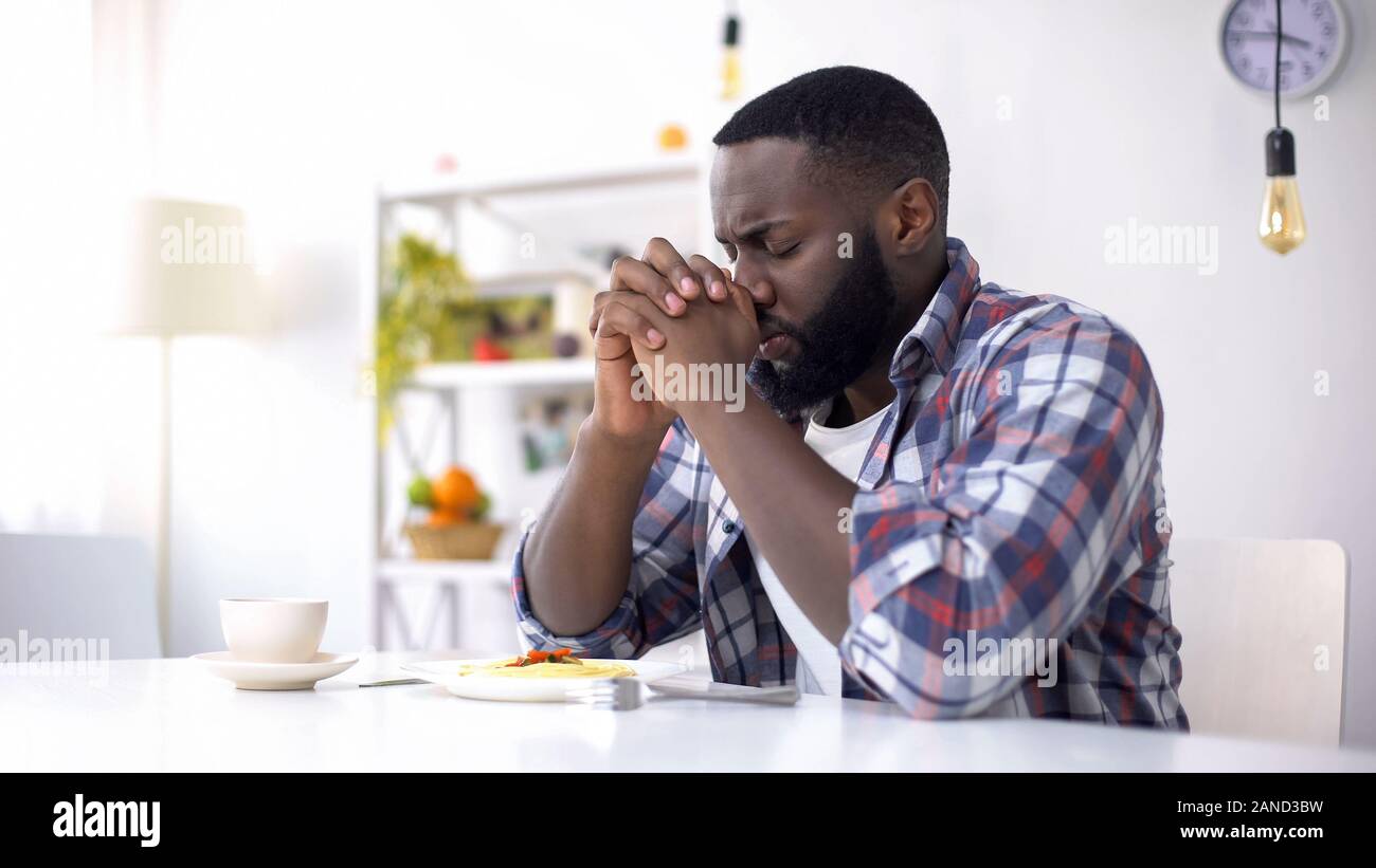 African-American man praying before lunch, thanking God for meal ...