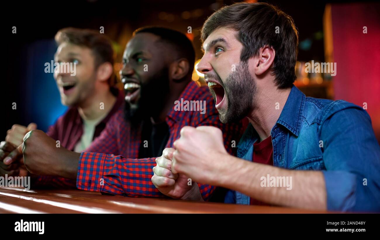 Extremely happy multiracial friends celebrating victory of national ...