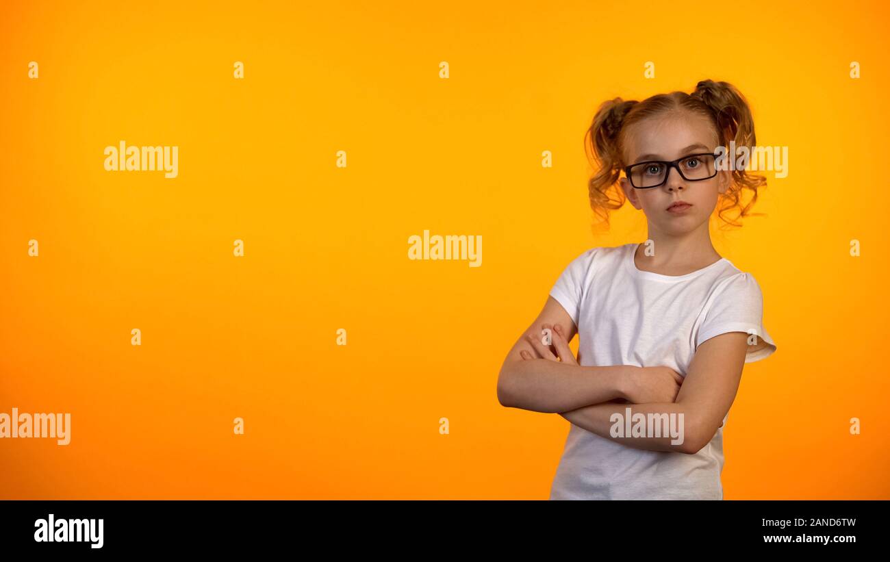 Funny serious preteen schoolgirl with hands crossed on chest looking to ...