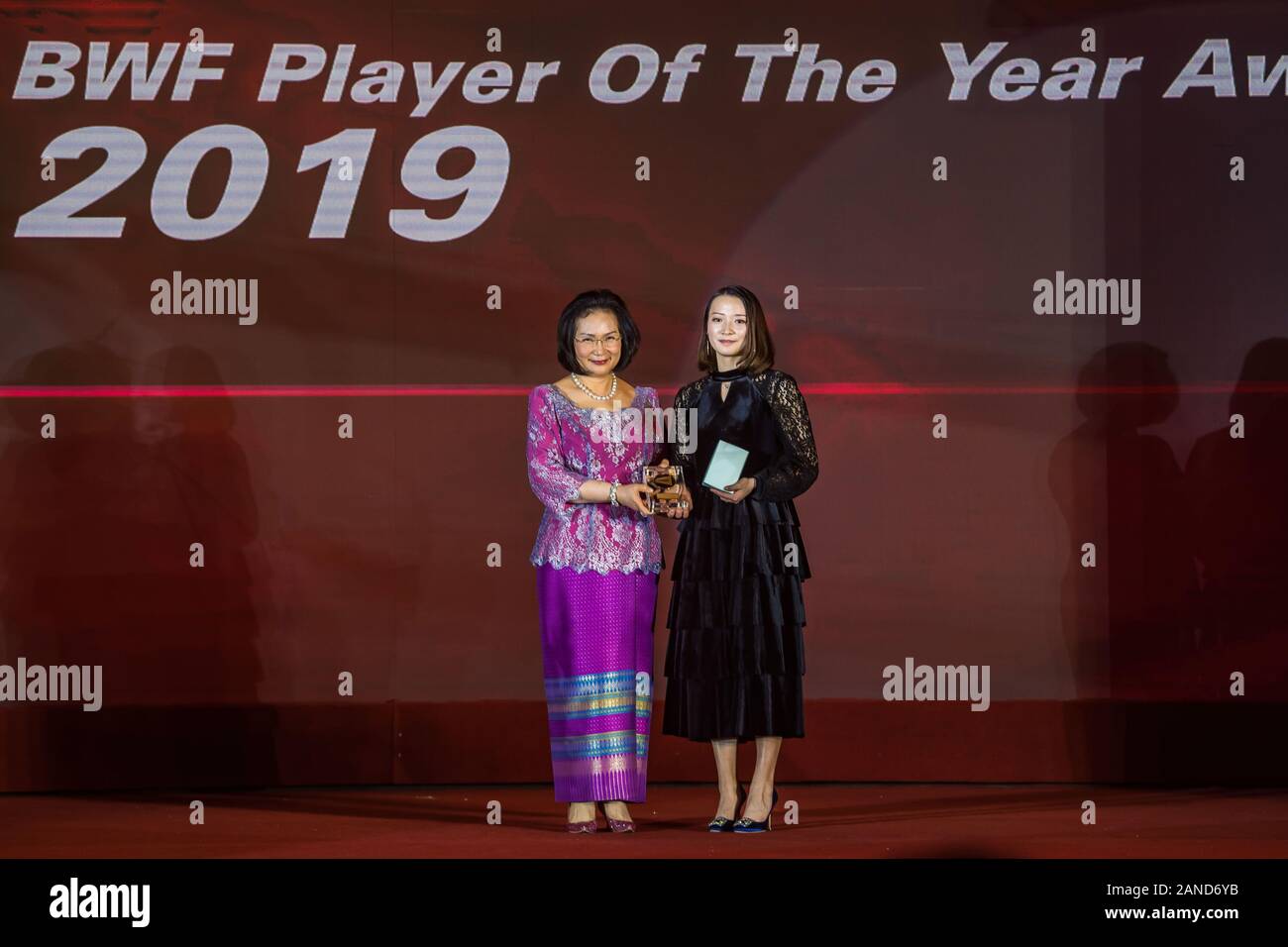 Japanese badminton player Huang Yaqiong, right, is honored with the ...
