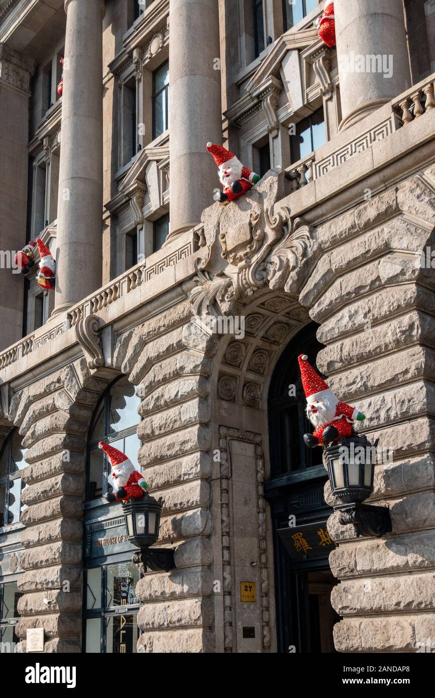 Santa Claus figures are "climbing up" a wall of a building by the Bund ...