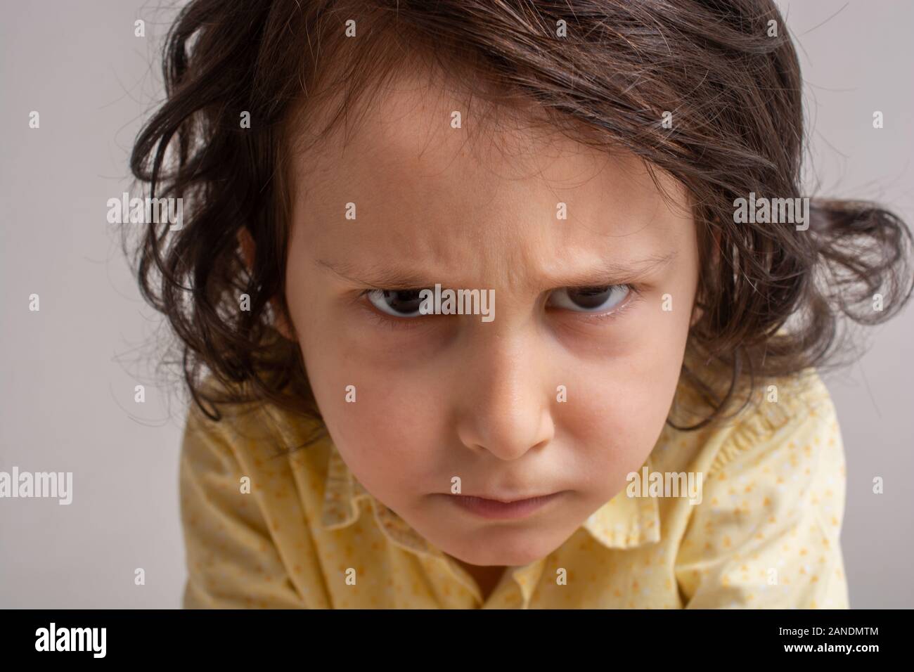 Little cute boy trying to make a serious face Stock Photo - Alamy