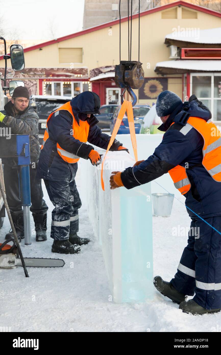 Workers in winter workwear installing ice panels Stock Photo - Alamy