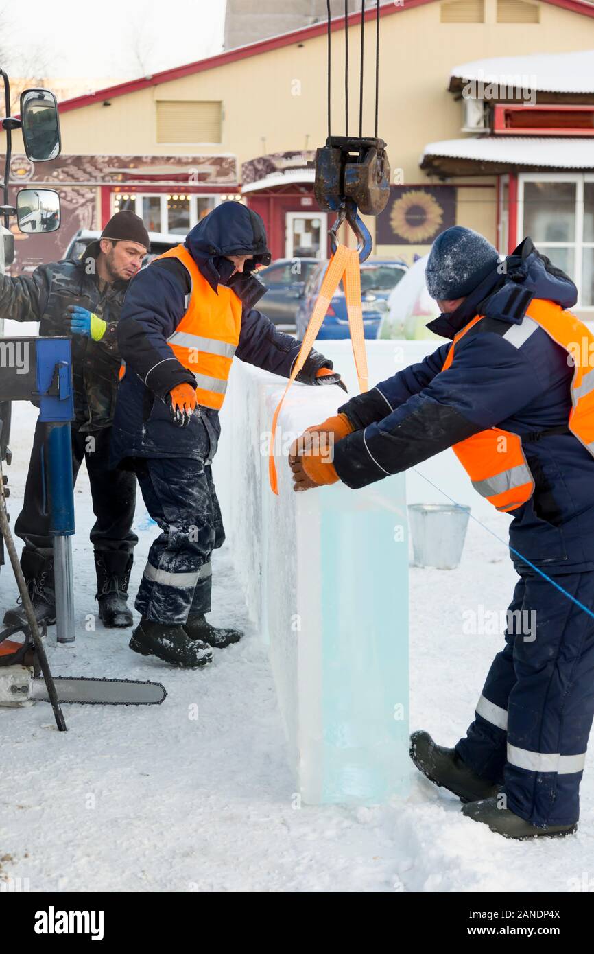 Workers in winter workwear installing ice panels Stock Photo - Alamy