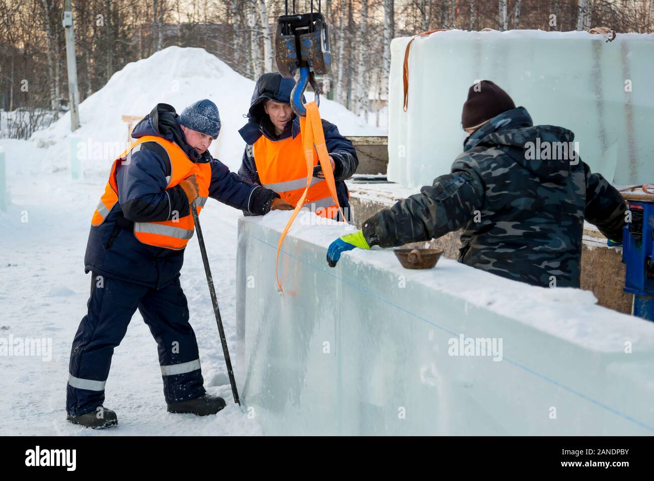 Workers in winter workwear installing ice panels Stock Photo - Alamy