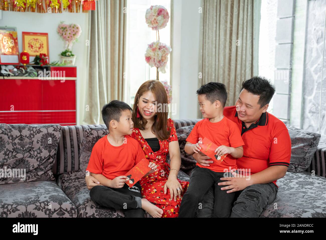 Asian family with two son holding ang pao chatting together Stock Photo ...