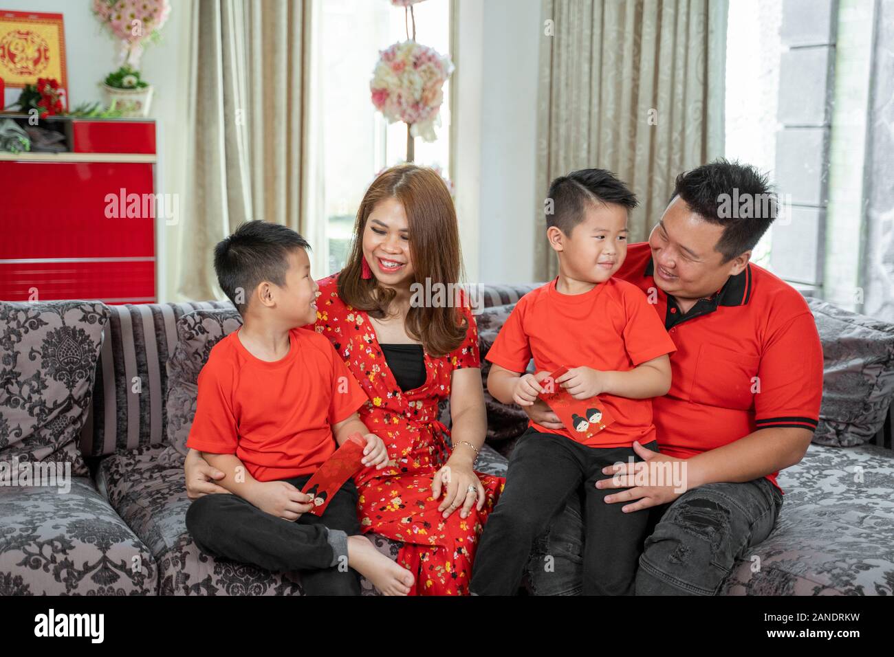Asian chinese family with two son holding ang pao when chatting ...