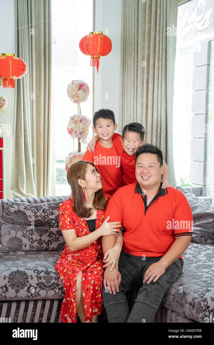 Asian chinese family with two son holding ang pao smiling when sitting ...